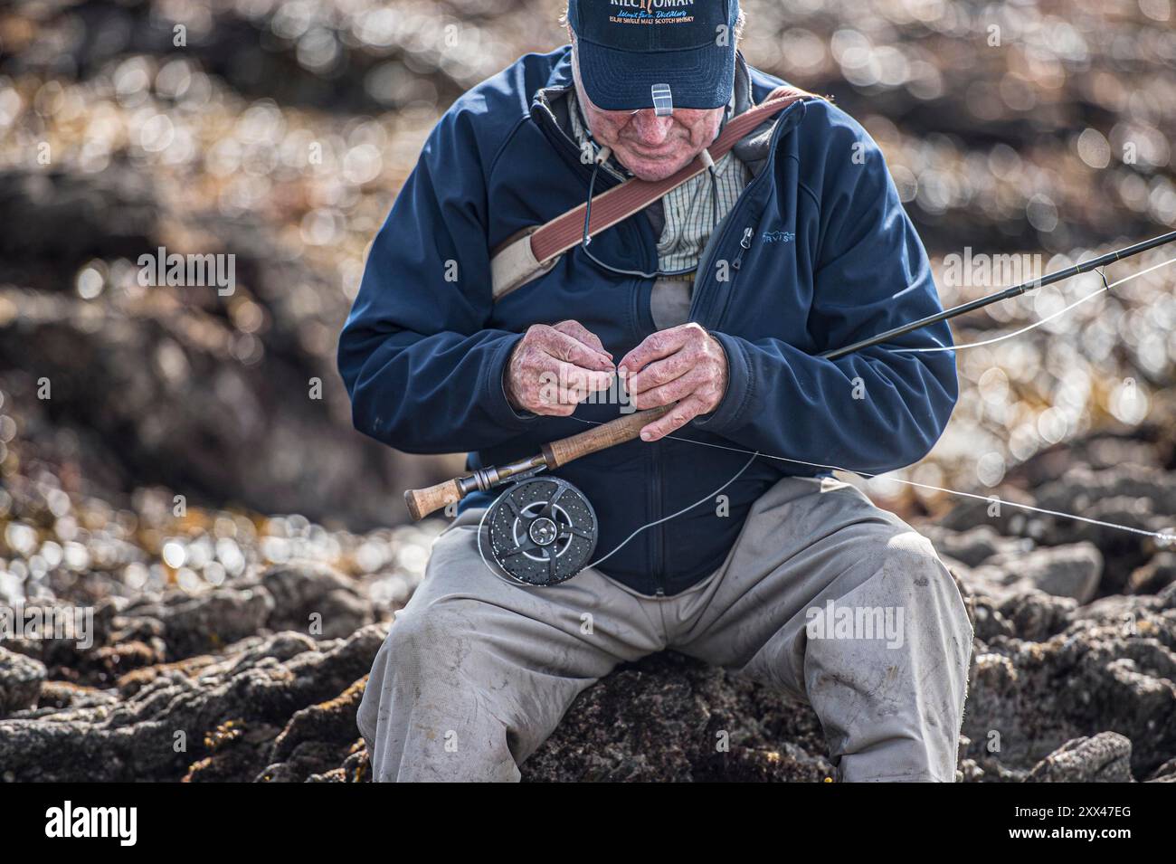 adult white male, putting a fly on his fly fishing rod Stock Photo - Alamy