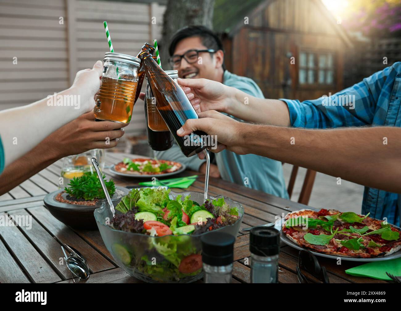 Dinner, alcohol and people in backyard for toast, celebrate and ...