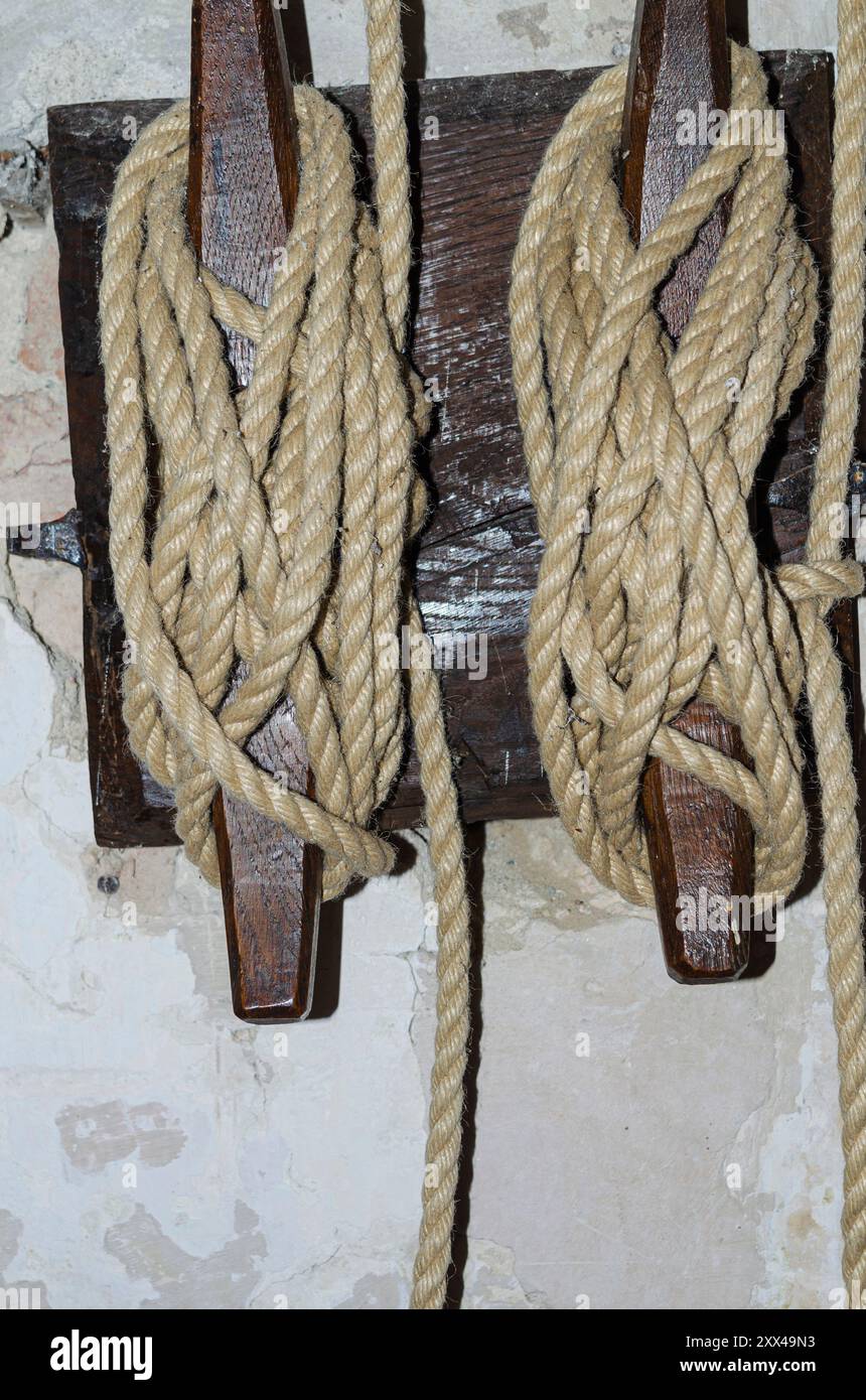 Two ropes tied in a figure of eight around wall mounted cleats securing ...