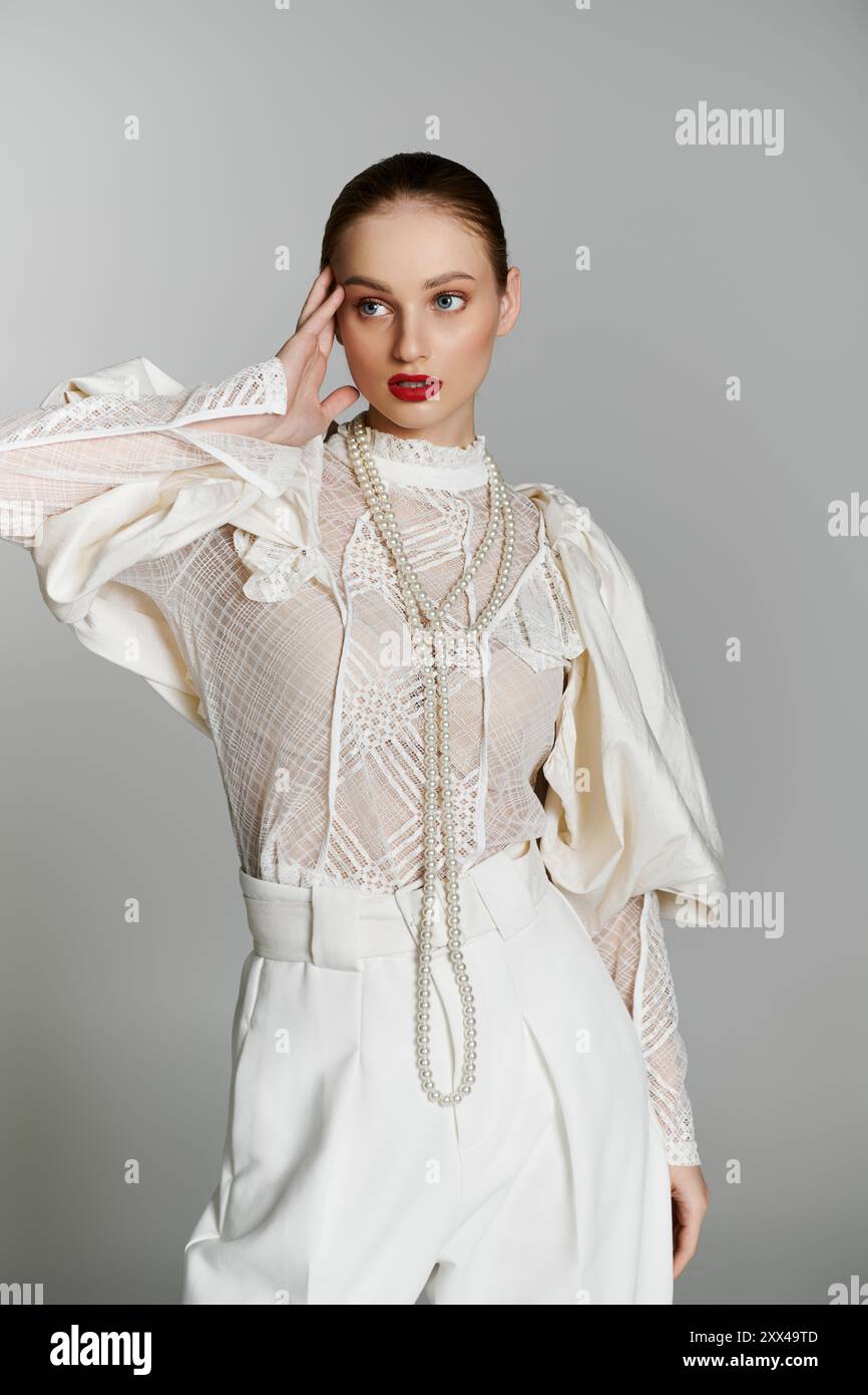 A young woman in a white lace blouse and pearl necklace poses against a ...