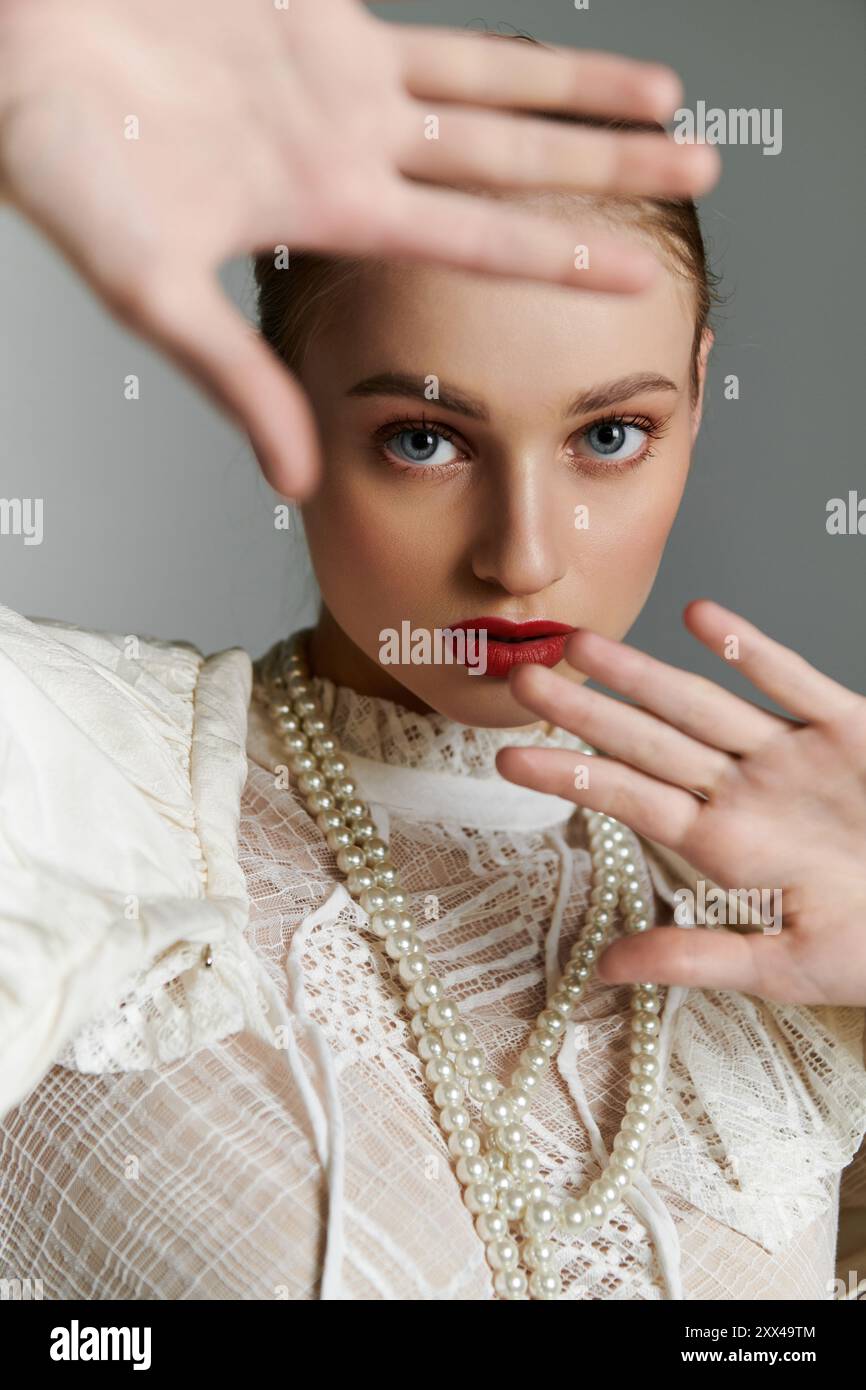 Young woman poses for portrait with hands in front of face, showing ...