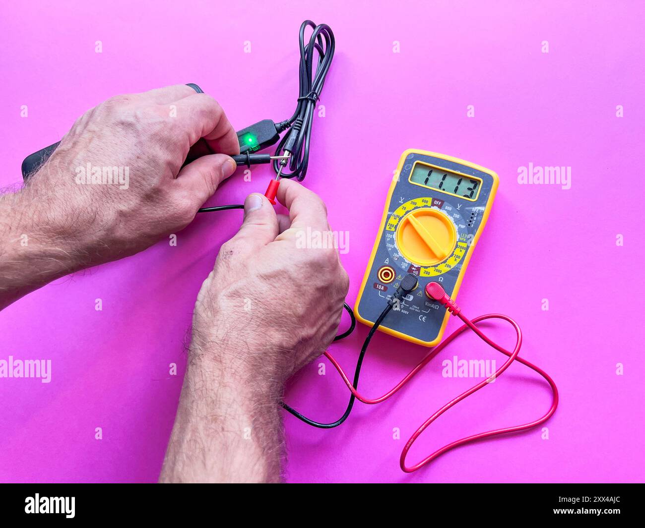 checking the adapter voltage with a multimeter. on the background Stock ...