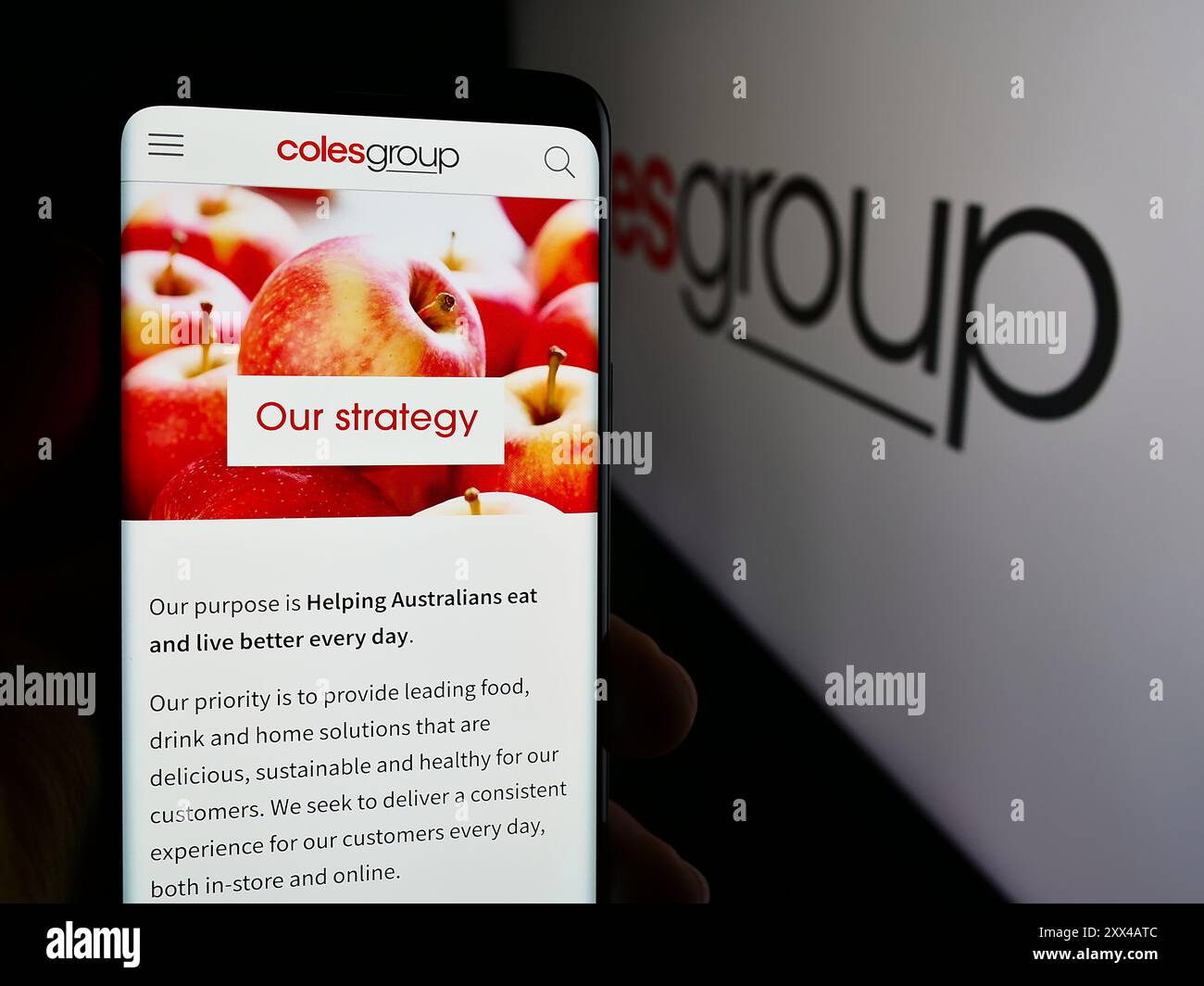 Person holding cellphone with webpage of Australian retail company ...
