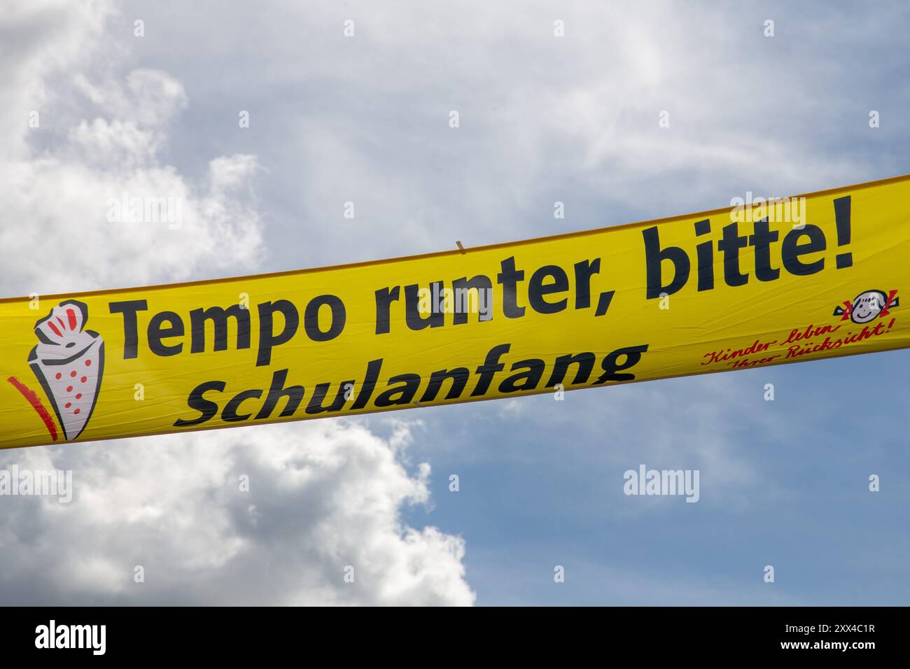Symbol image of the start of school: Banner above a road with a warning ...