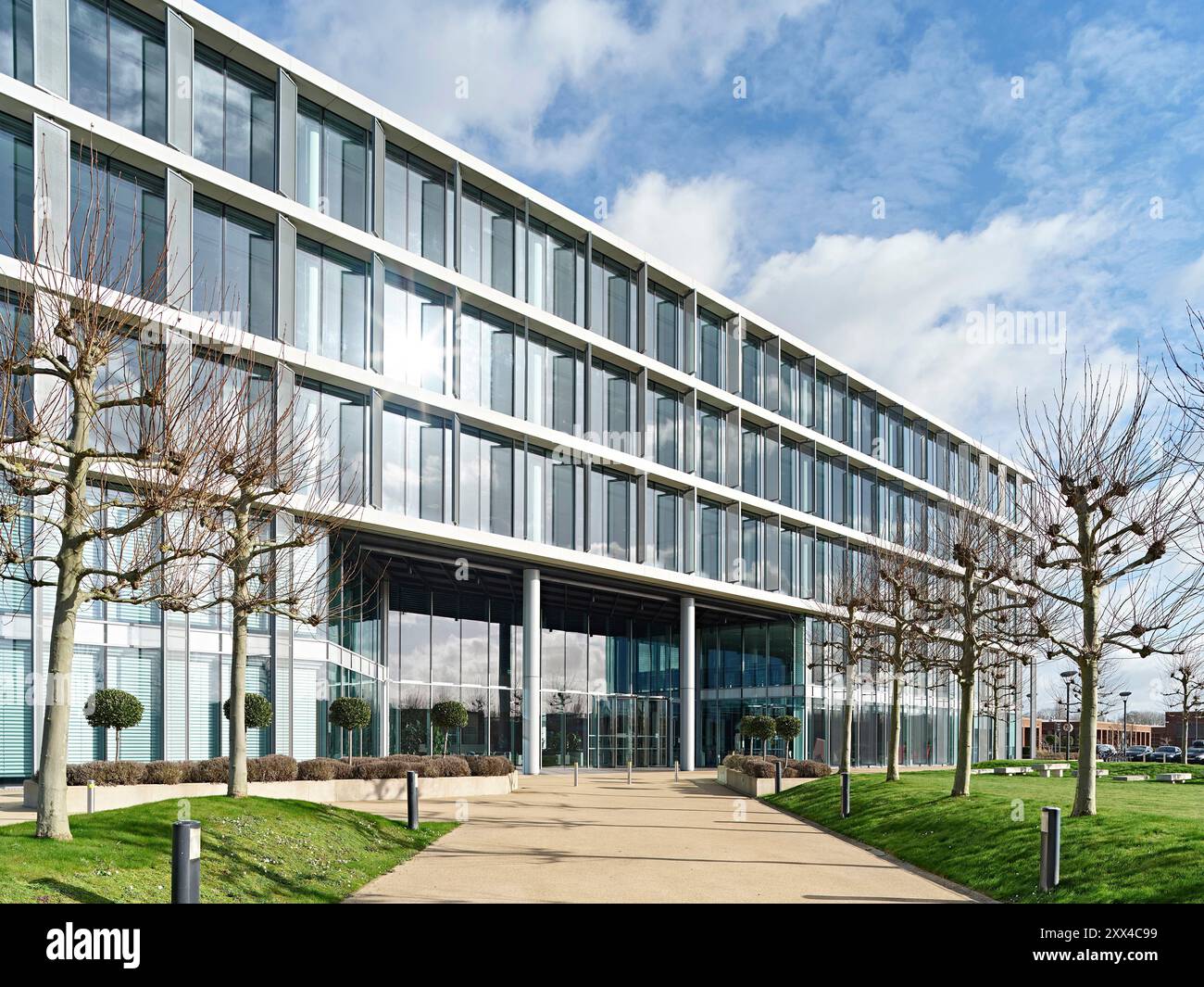 Sunlit oblique elevation of office building from approach. Building ...