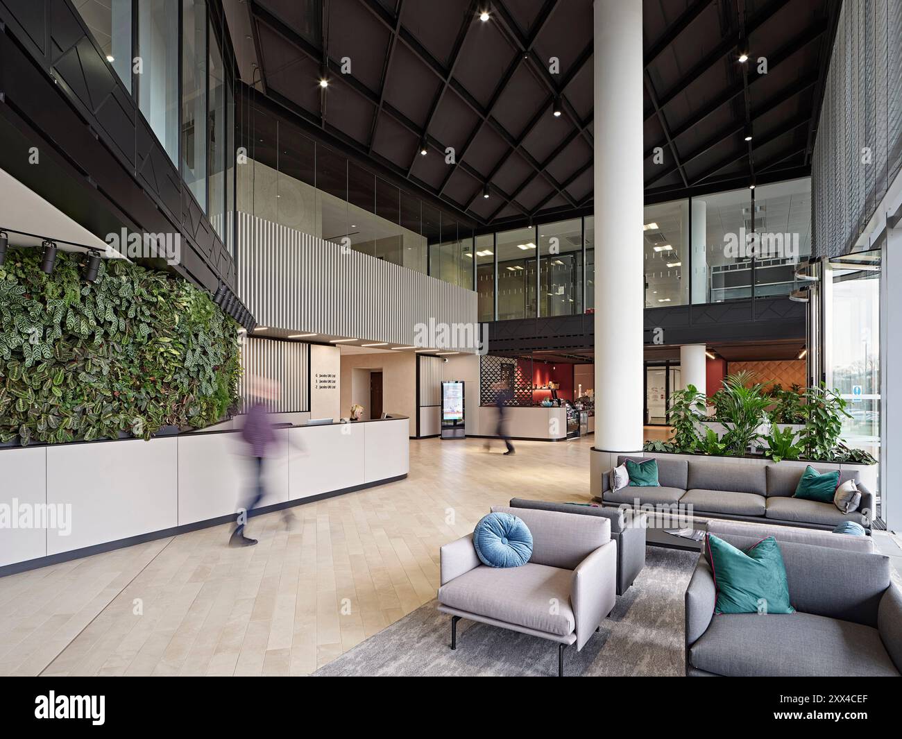 Foyer with reception desk and waiting lounge, figures passing. Building ...