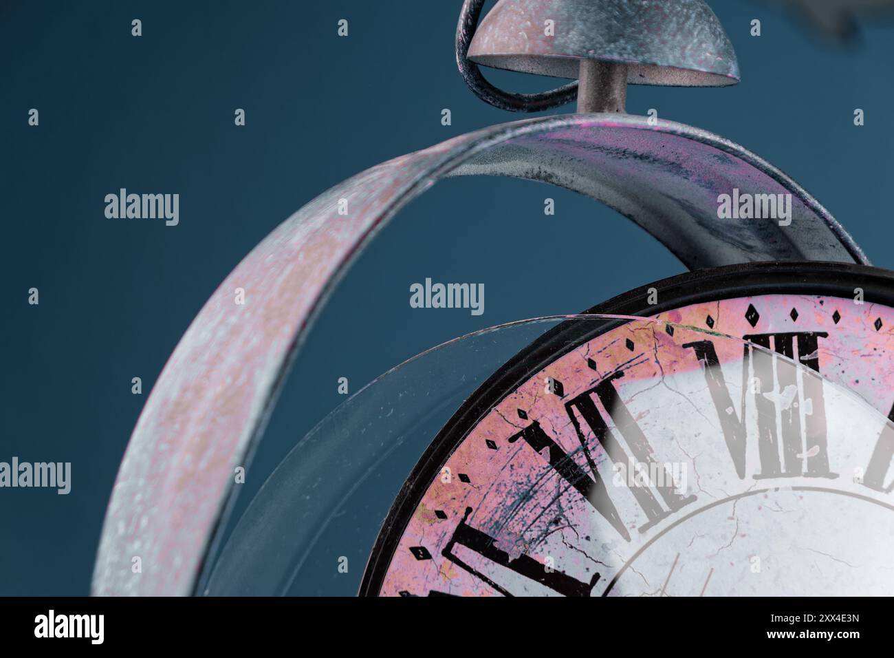 Broken old analog clock with glass and metal frame on wooden table ...