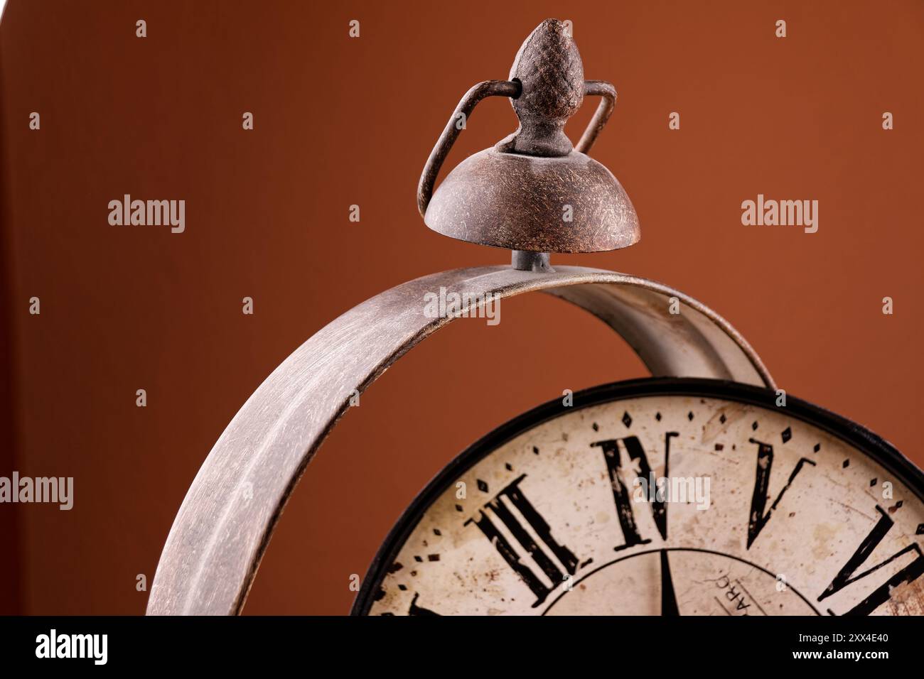 Broken old analog clock with glass and metal frame on wooden table ...