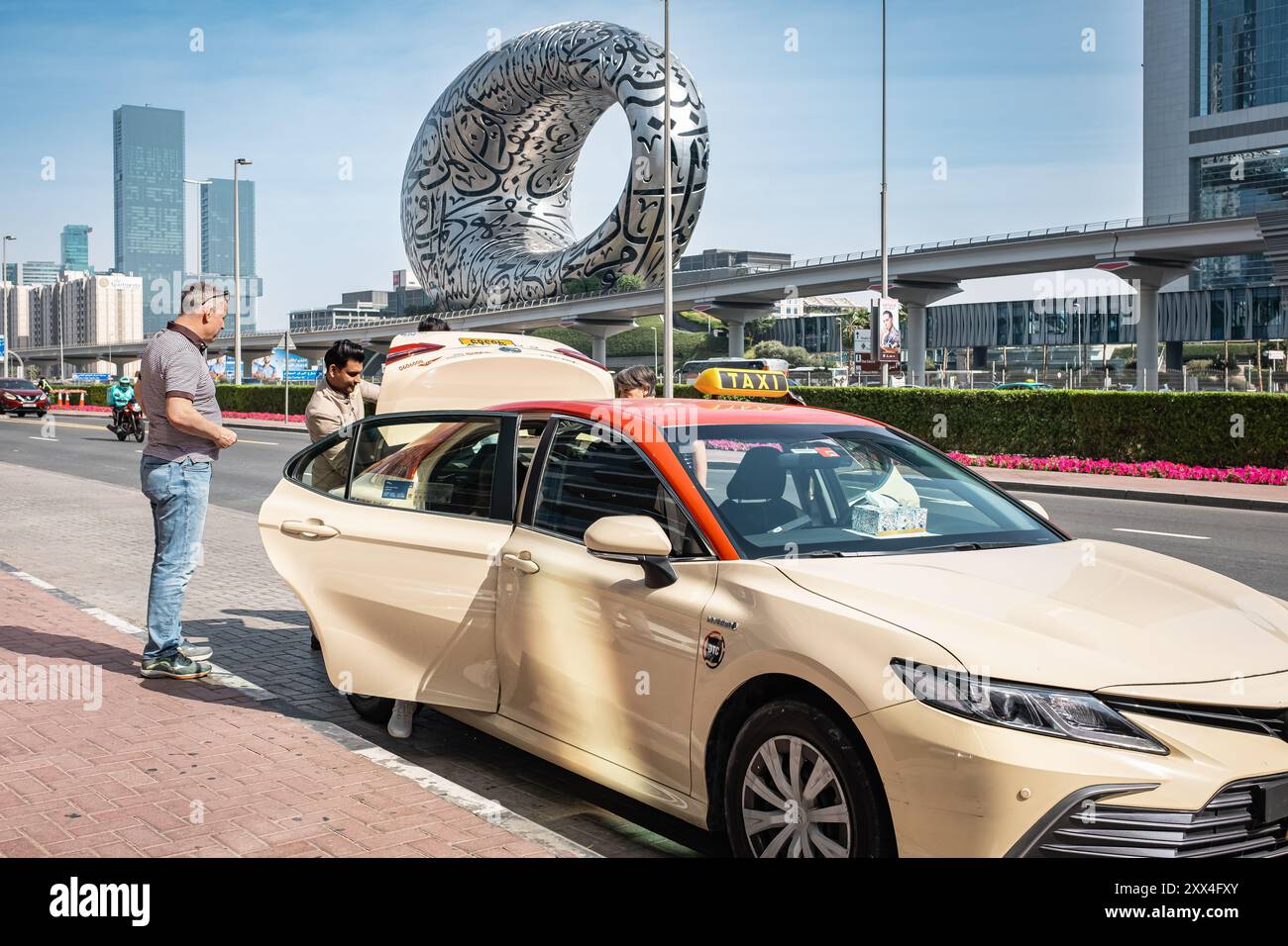 Taxi in Dubai. Man tourist with a luggage taking a taxi at roadside ...