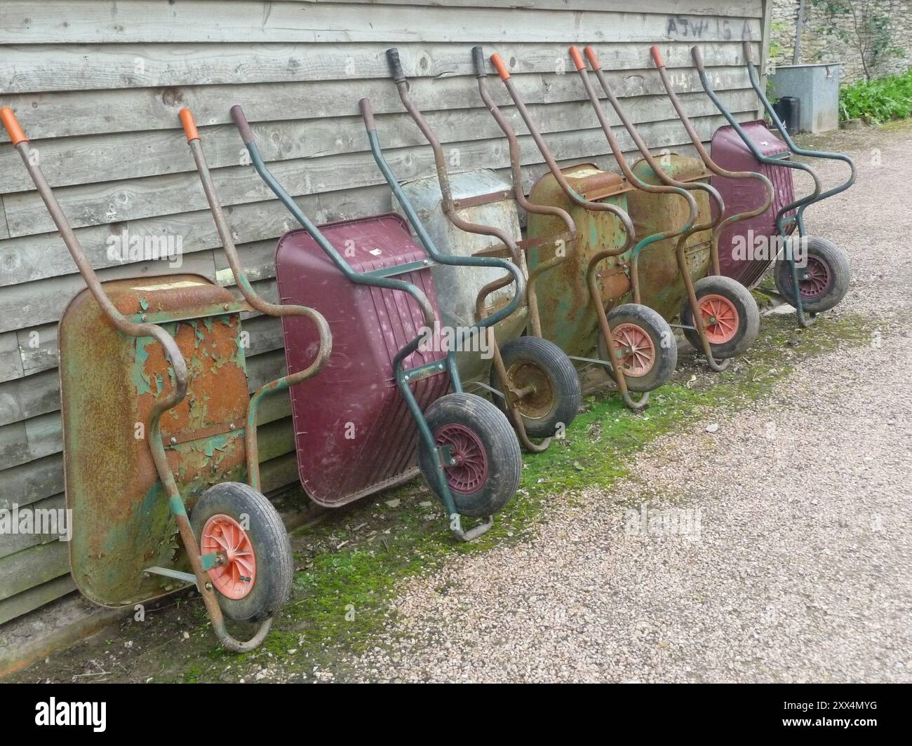 different colored wheelbarrows on a wall Stock Photo - Alamy