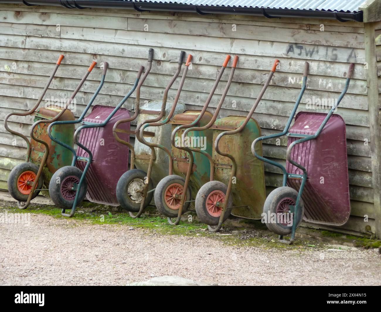 different colored wheelbarrows on a wall Stock Photo - Alamy