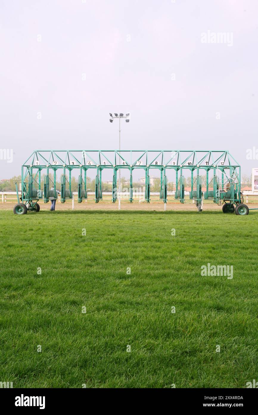 Empty horse racing starting stalls waiting for riders. Green colored ...