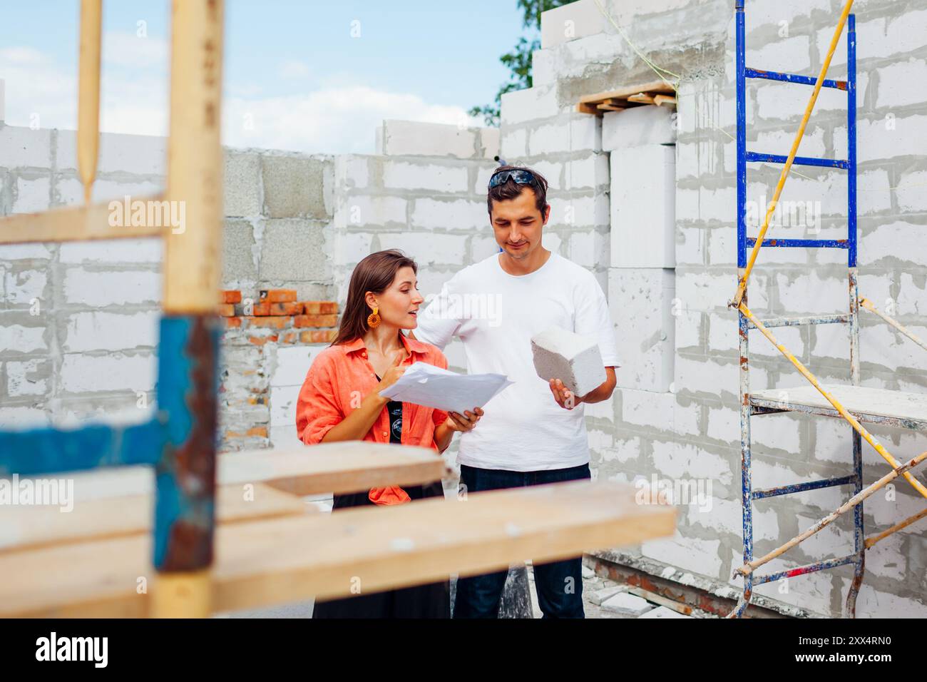 Happy young couple checking their future house under construction ...