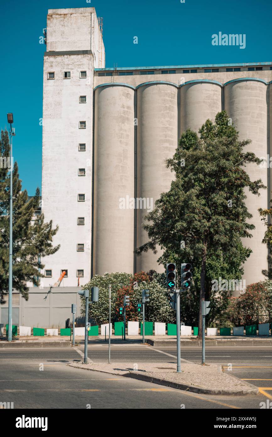 A vertical shot of a grain elevator with large concrete silos ...