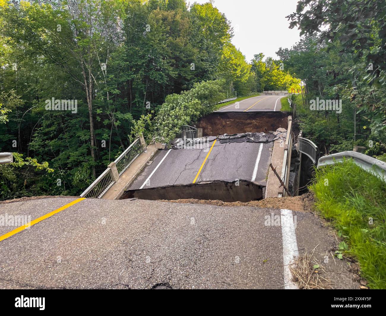 Road and bridge destroyed by the heavy rain and flood. Big holes before ...