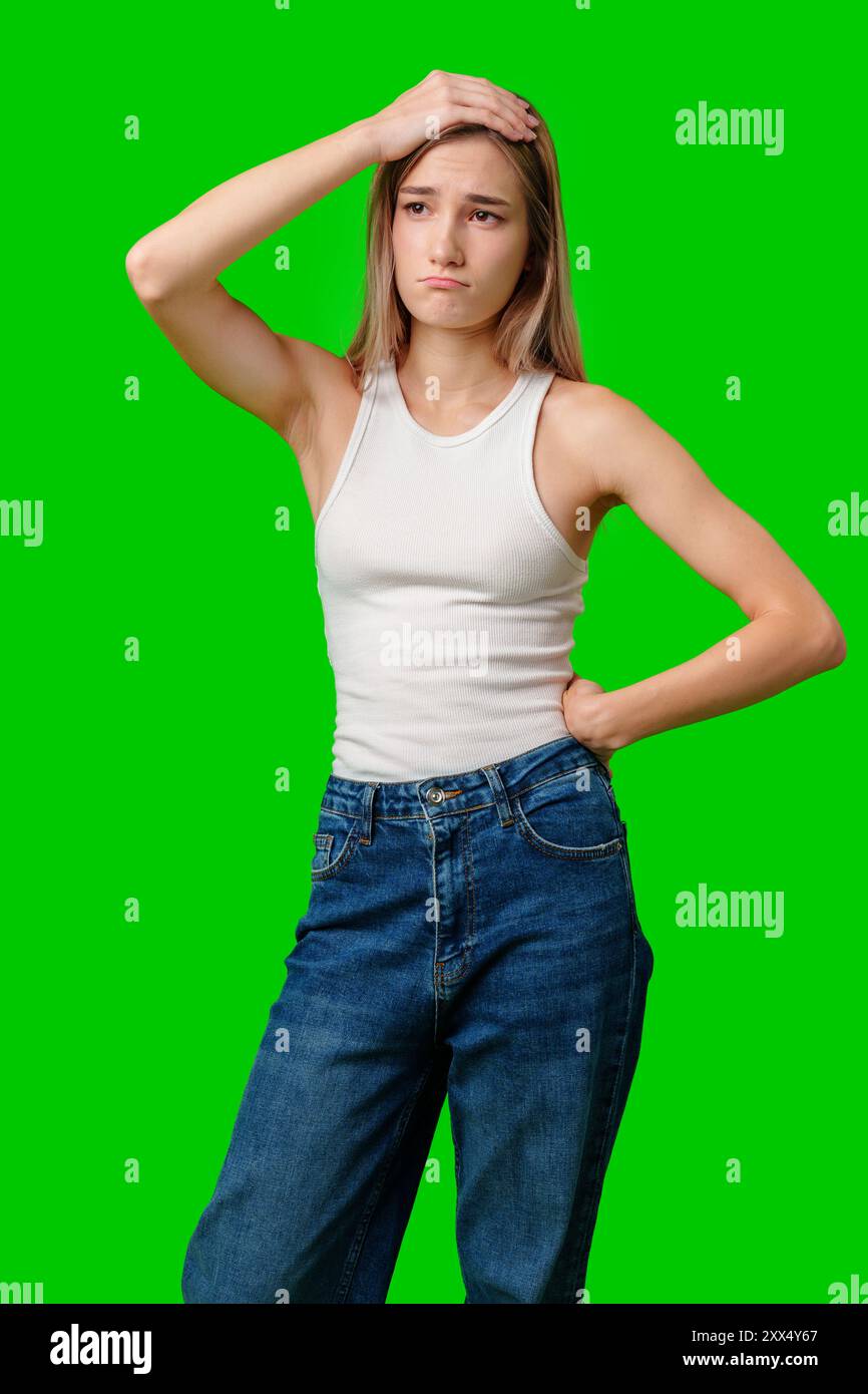 Young Woman In White Tank Top And Blue Jeans With A Worried Expression ...