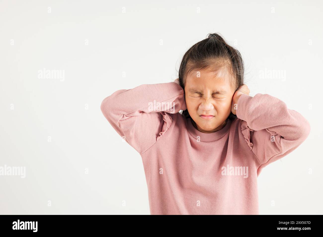 Asian young kid girl closed ears with hand palm and close eyes, studio ...