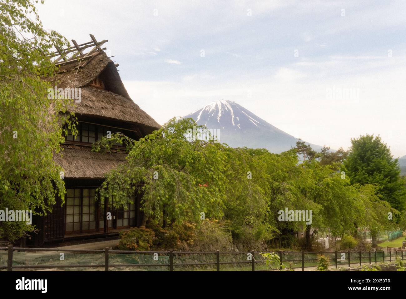 Traditional thatched-roof homes with Mt. Fuji in the background on a ...