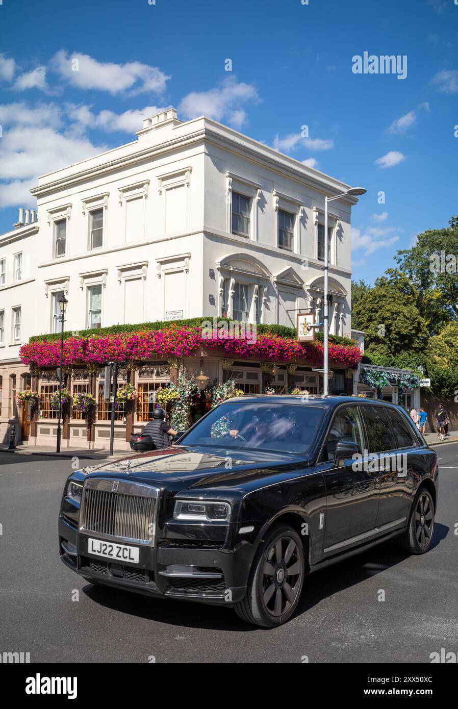A black Rolls-Royce Cullinan car is driven past the Cadogan Arms pub ...