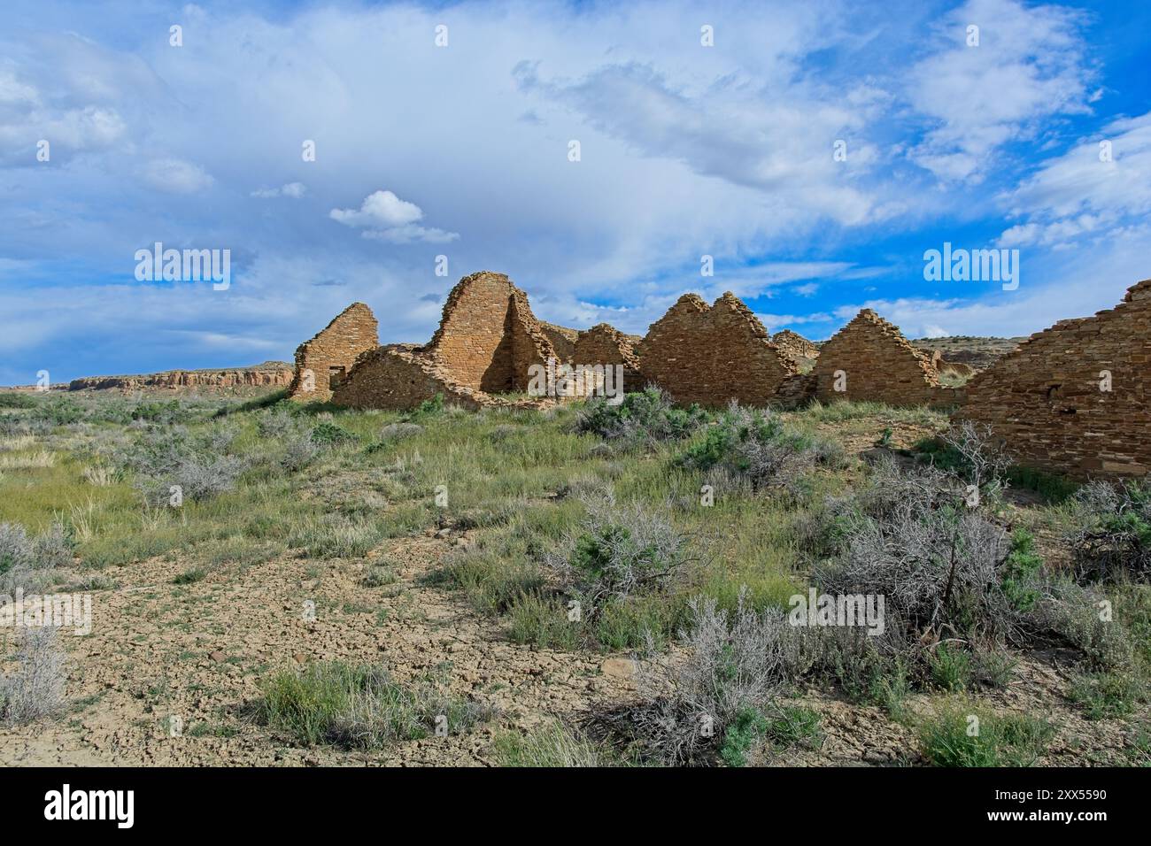 Stone slab masonry ruins in desert grasslands under dynamic sky at ...