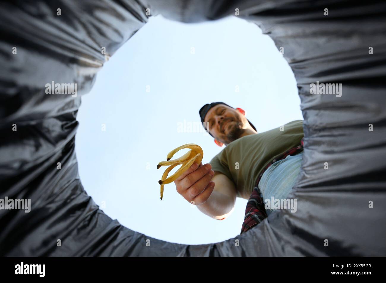 Man throwing banana peel into garbage bin outdoors, bottom view Stock ...