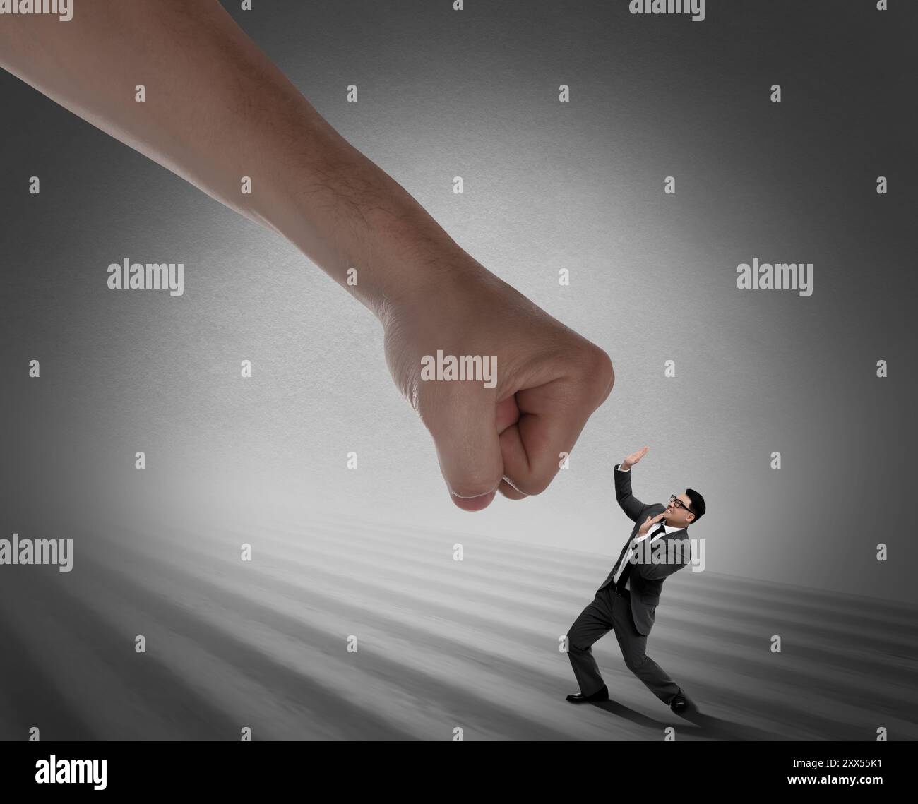 Small businessman dodging big fist on color background. Authority ...
