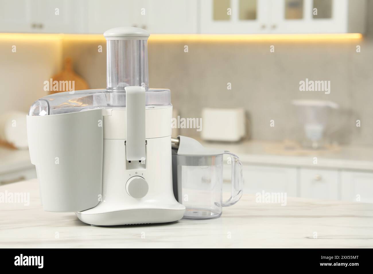 Modern juicer on white marble table in kitchen, space for text Stock ...