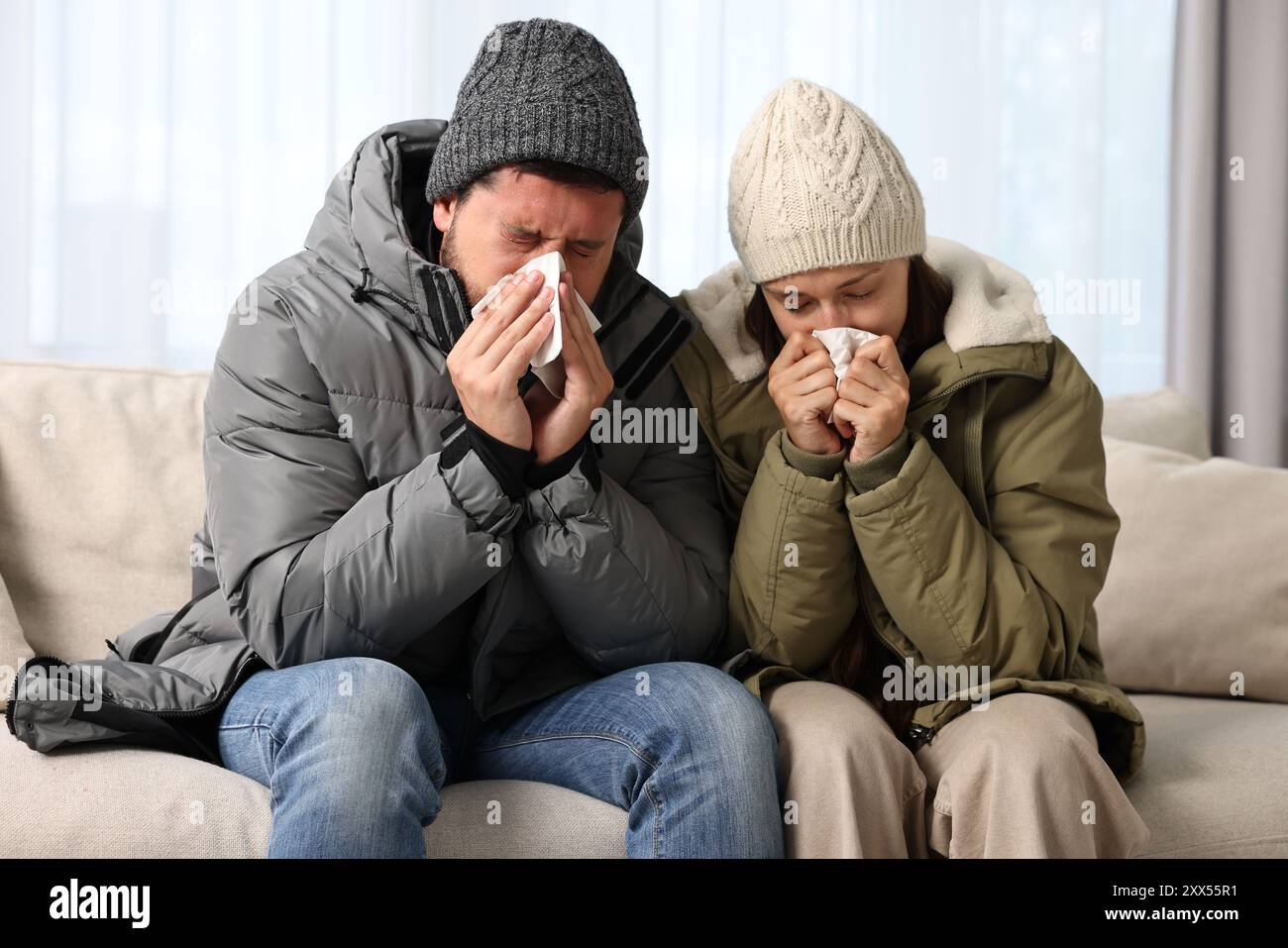 Cold symptom. Couple suffering from fever on sofa at home Stock Photo ...
