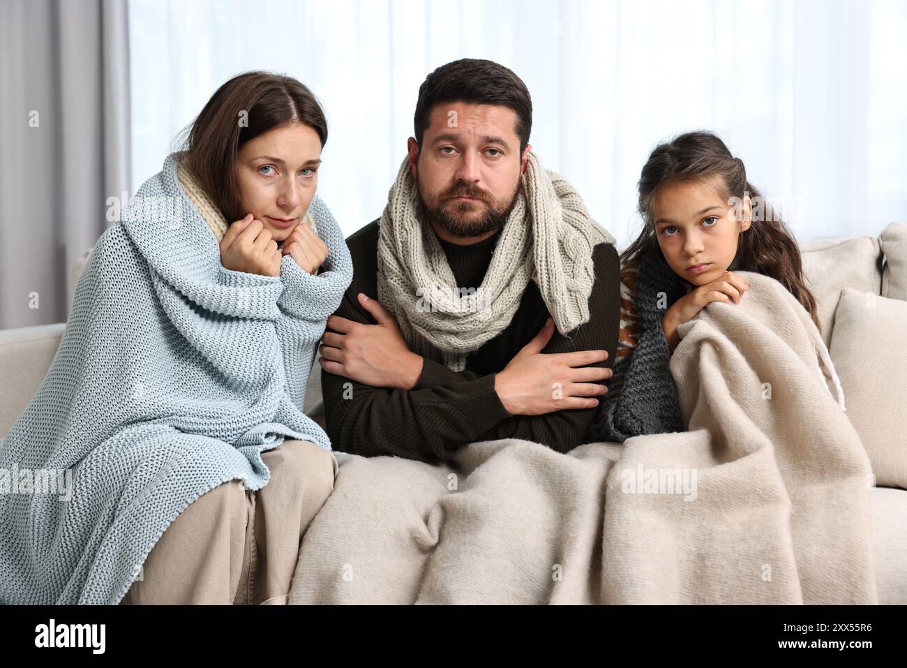 Cold symptom. Family suffering from fever on sofa at home Stock Photo ...