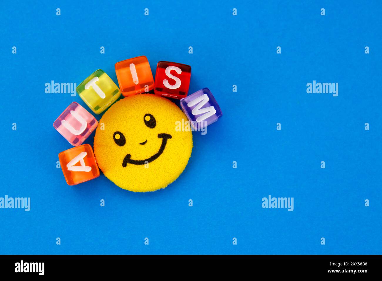 Happy face and colorful cubes that form the word autism Stock Photo - Alamy