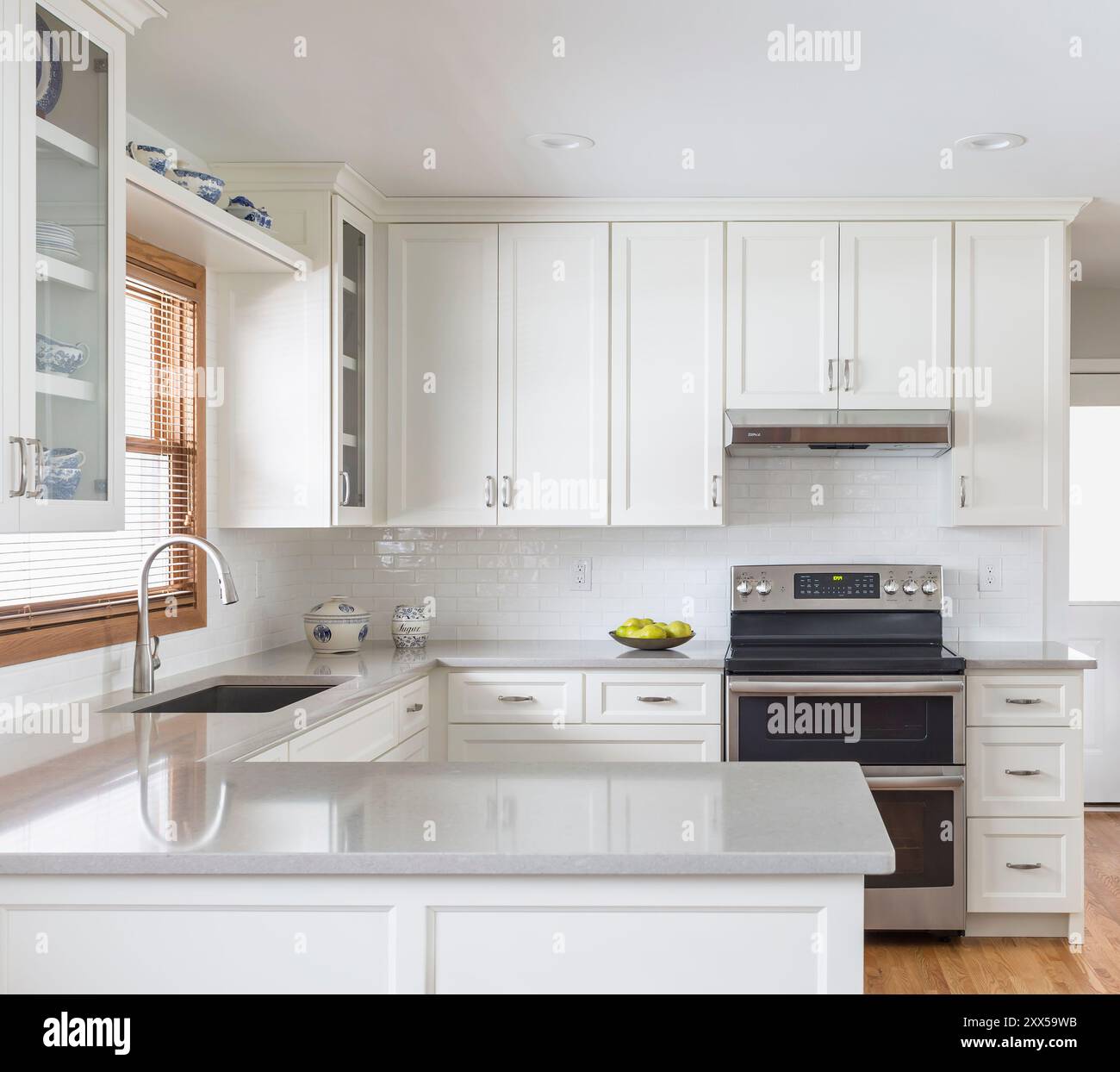 White U-shaped kitchen with gray quartz countertops Stock Photo - Alamy