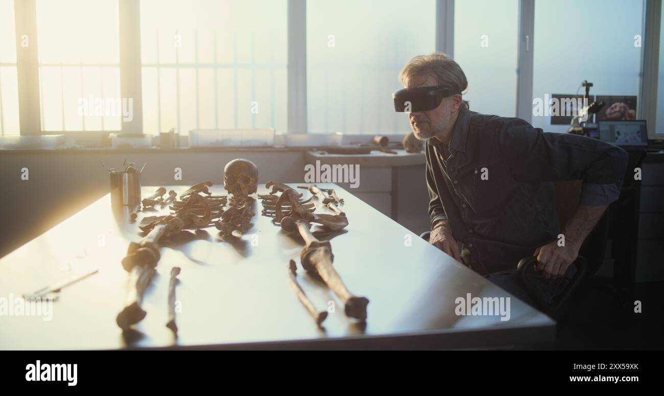 Mature archaeologist in AR headset studies remains of prehistoric ...