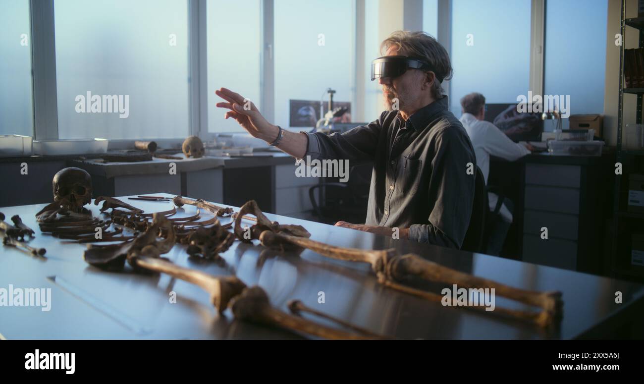 Mature archaeologist in VR headset studies remains of ancient extinct ...