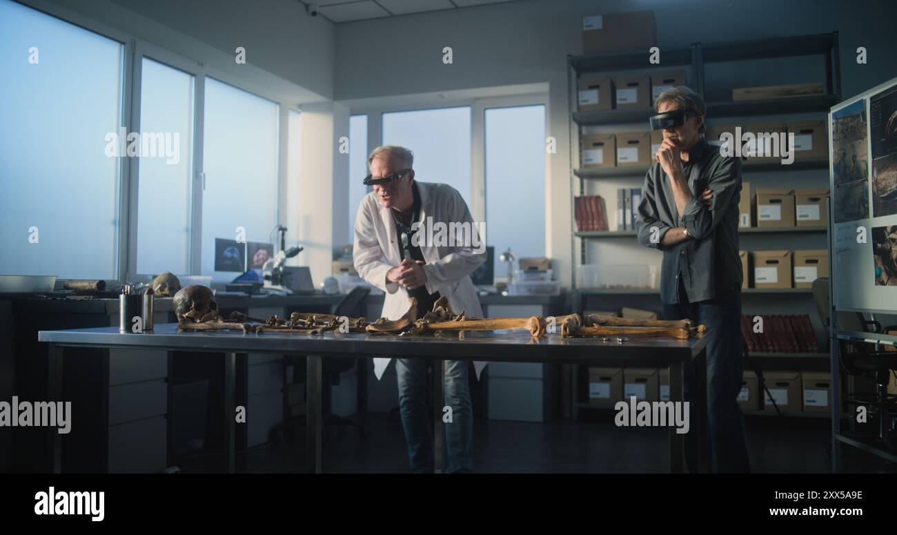 Two archaeologists wearing AR headsets study skeleton remains of ...