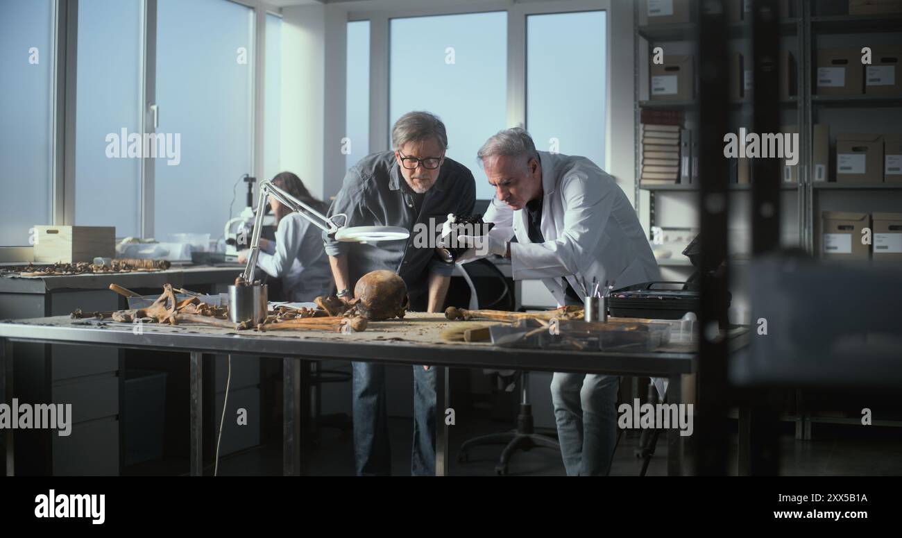 Senior paleoanthropologist takes photo of fossil remains of prehistoric ...