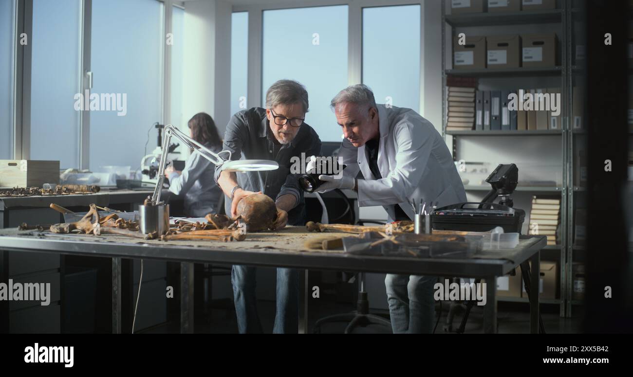 Senior paleoanthropologist takes photo of fossil remains of prehistoric ...