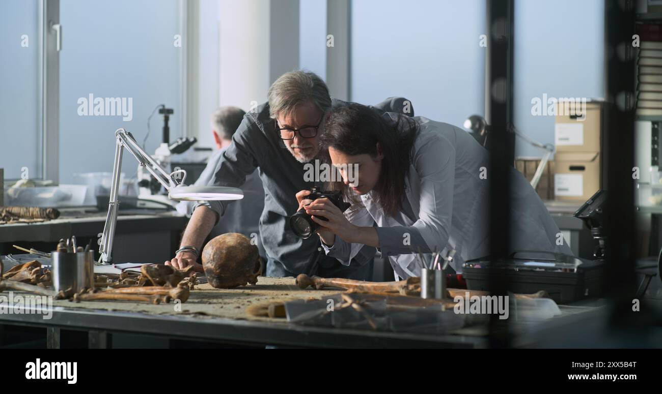 Female paleoanthropologist takes photo of fossil skull remains of ...