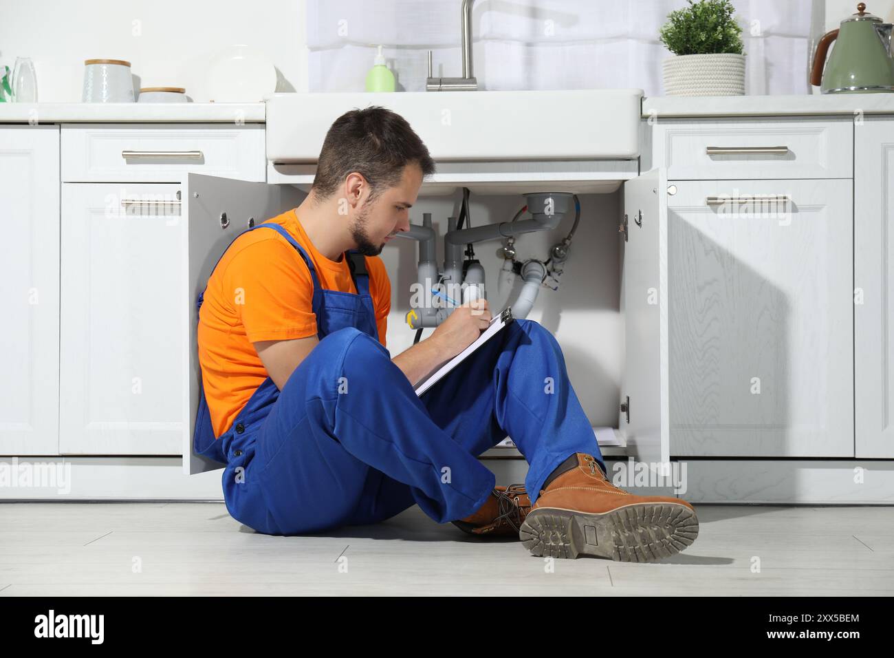 Professional plumber fixing piping system at home Stock Photo - Alamy