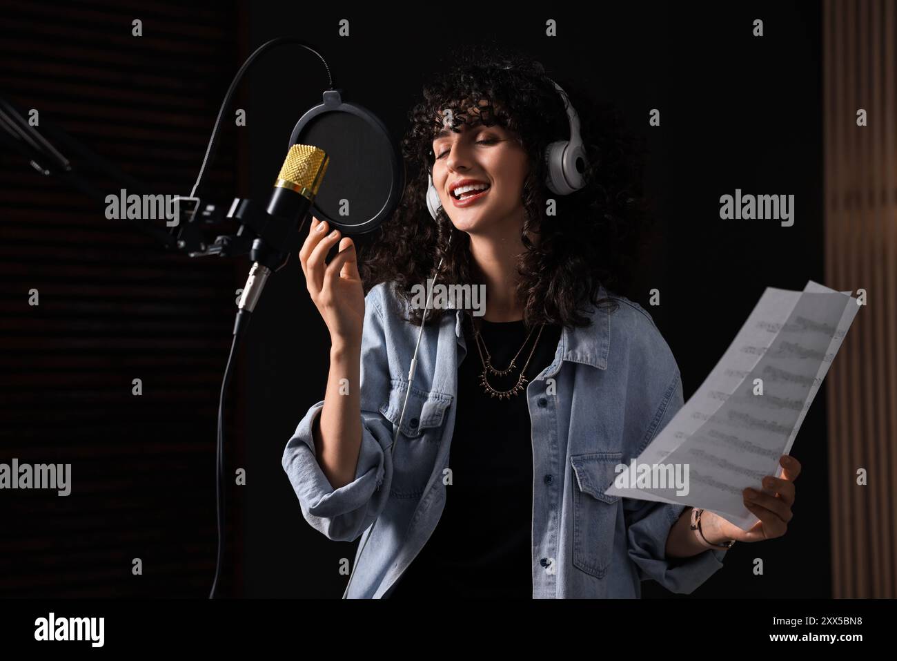 Vocalist singing into microphone in professional record studio Stock ...
