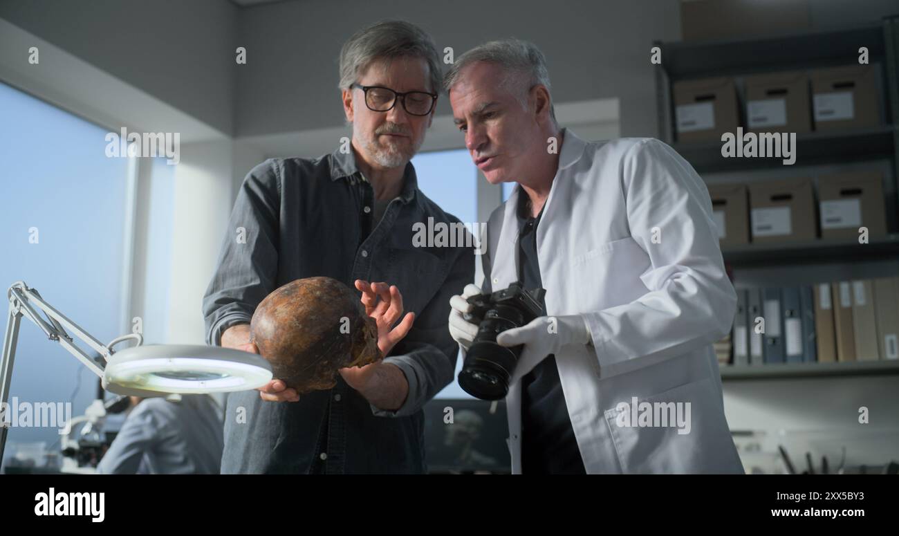 Senior paleoanthropologist takes photo of fossil remains of prehistoric ...