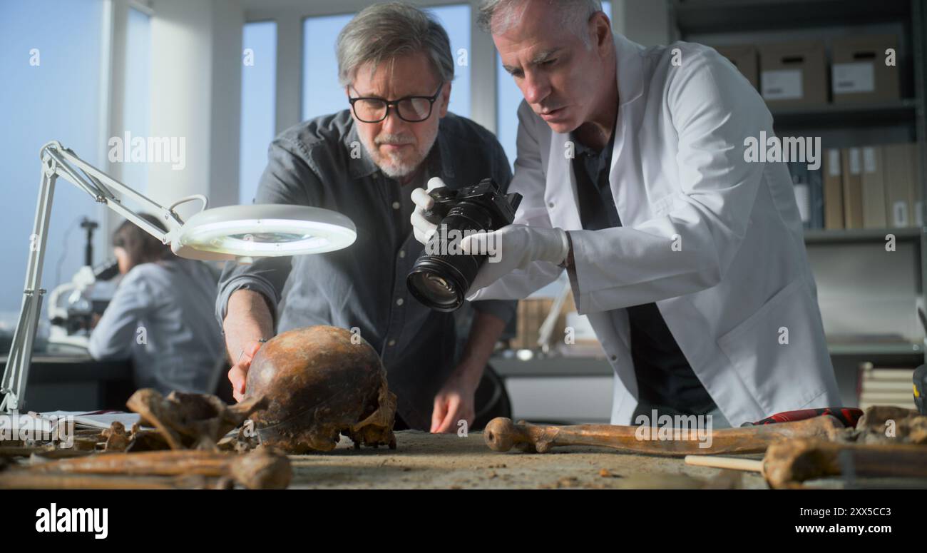 Senior paleoanthropologist takes photo of fossil remains of prehistoric ...