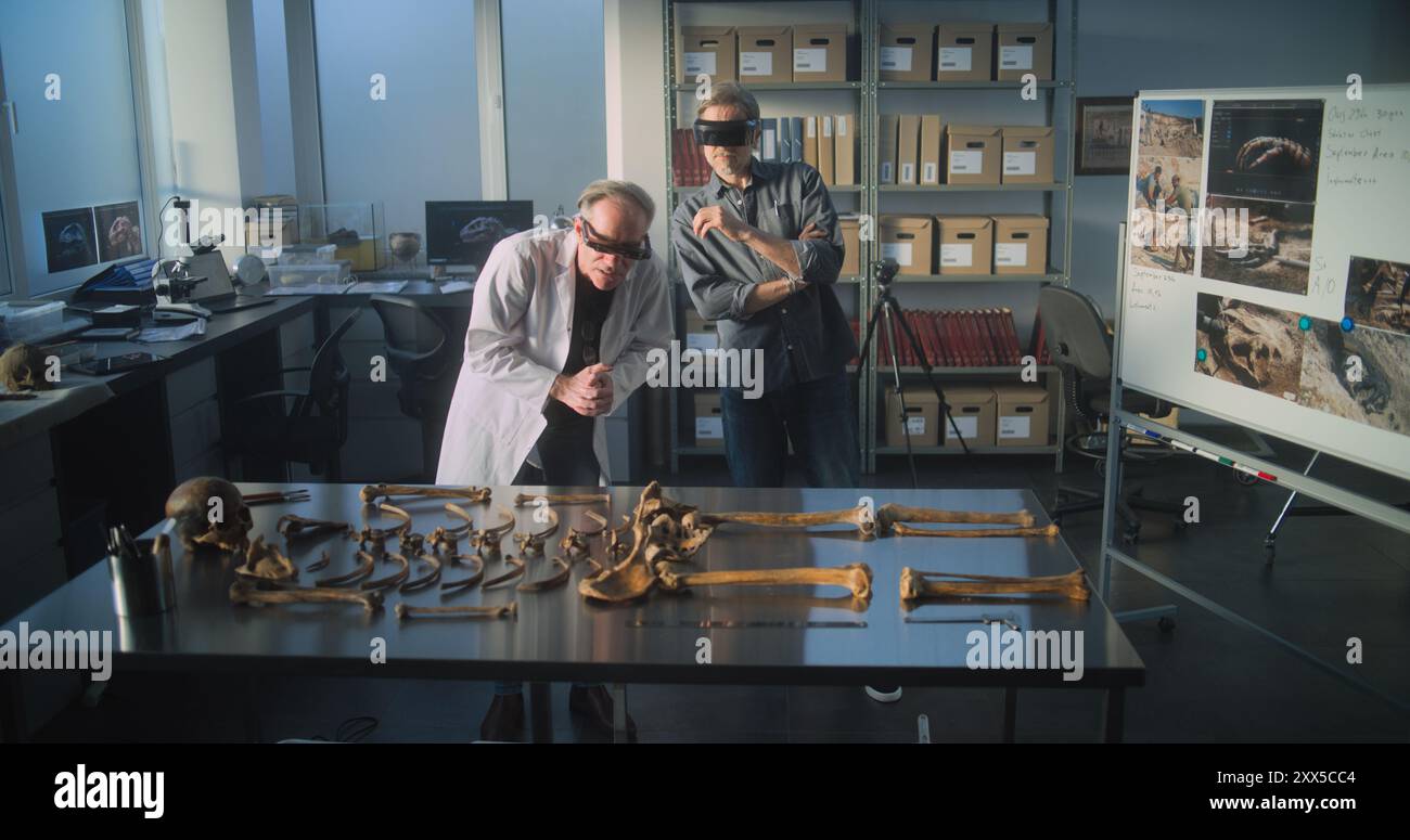 Two archaeologists in VR headsets study remains of ancient extinct ...