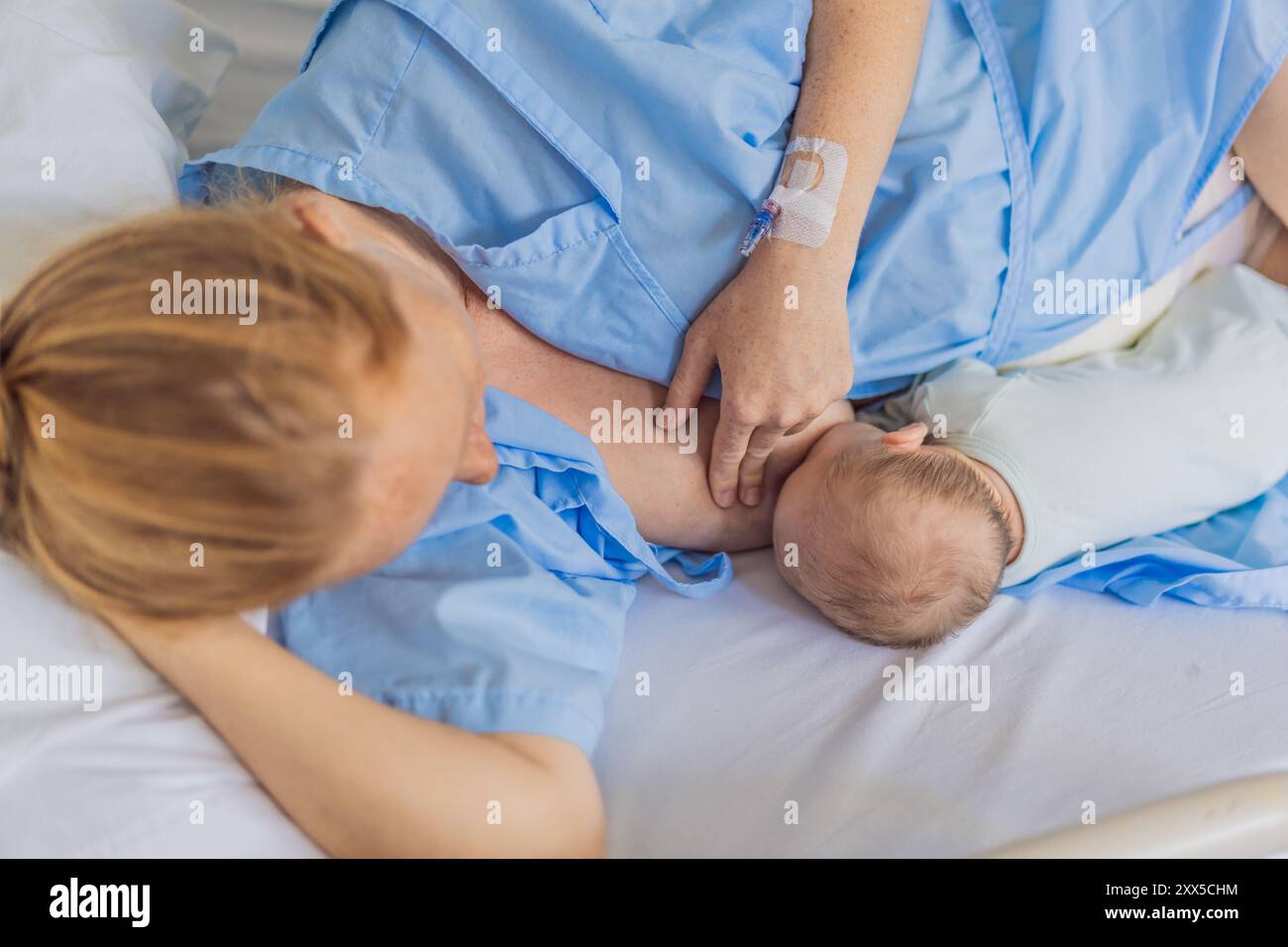A mom breastfeeds her newborn baby in the hospital. The intimate moment ...
