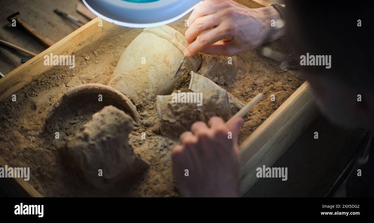 Close up of mature archaeologist cleaning cultural heritage of extinct ...