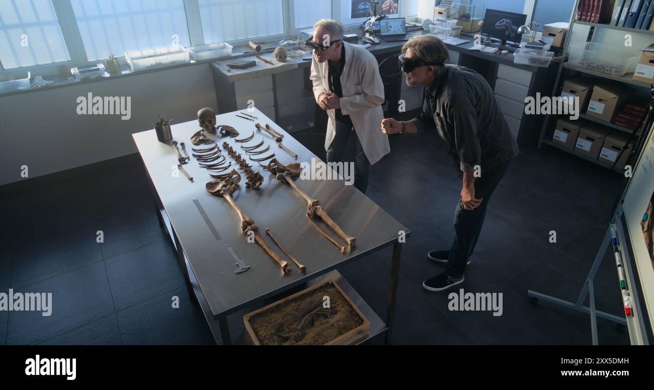 Two archaeologists in VR headsets study remains of ancient extinct ...