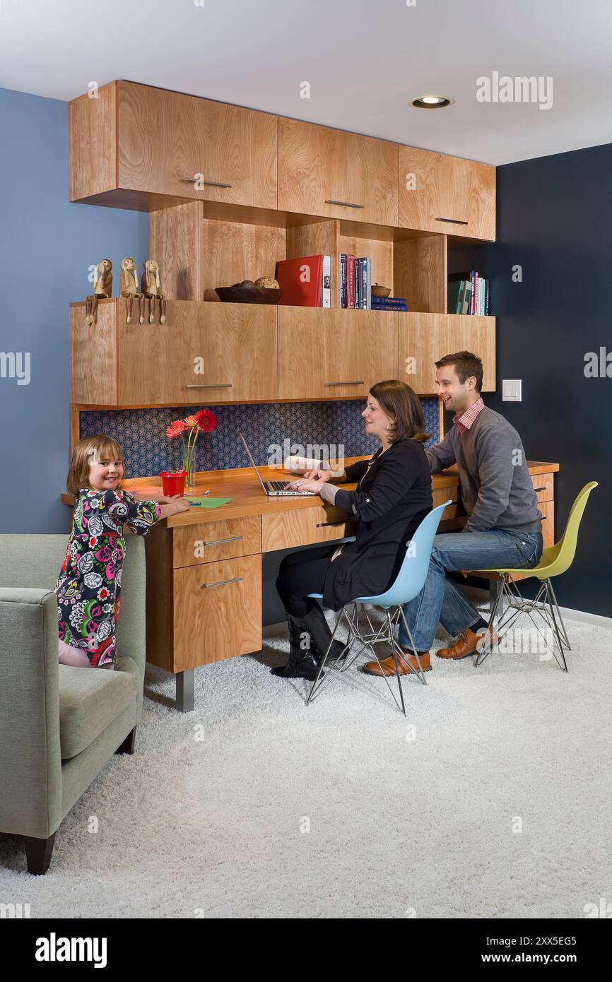 An architect and a homeowner discuss plans sitting at interesting desk ...