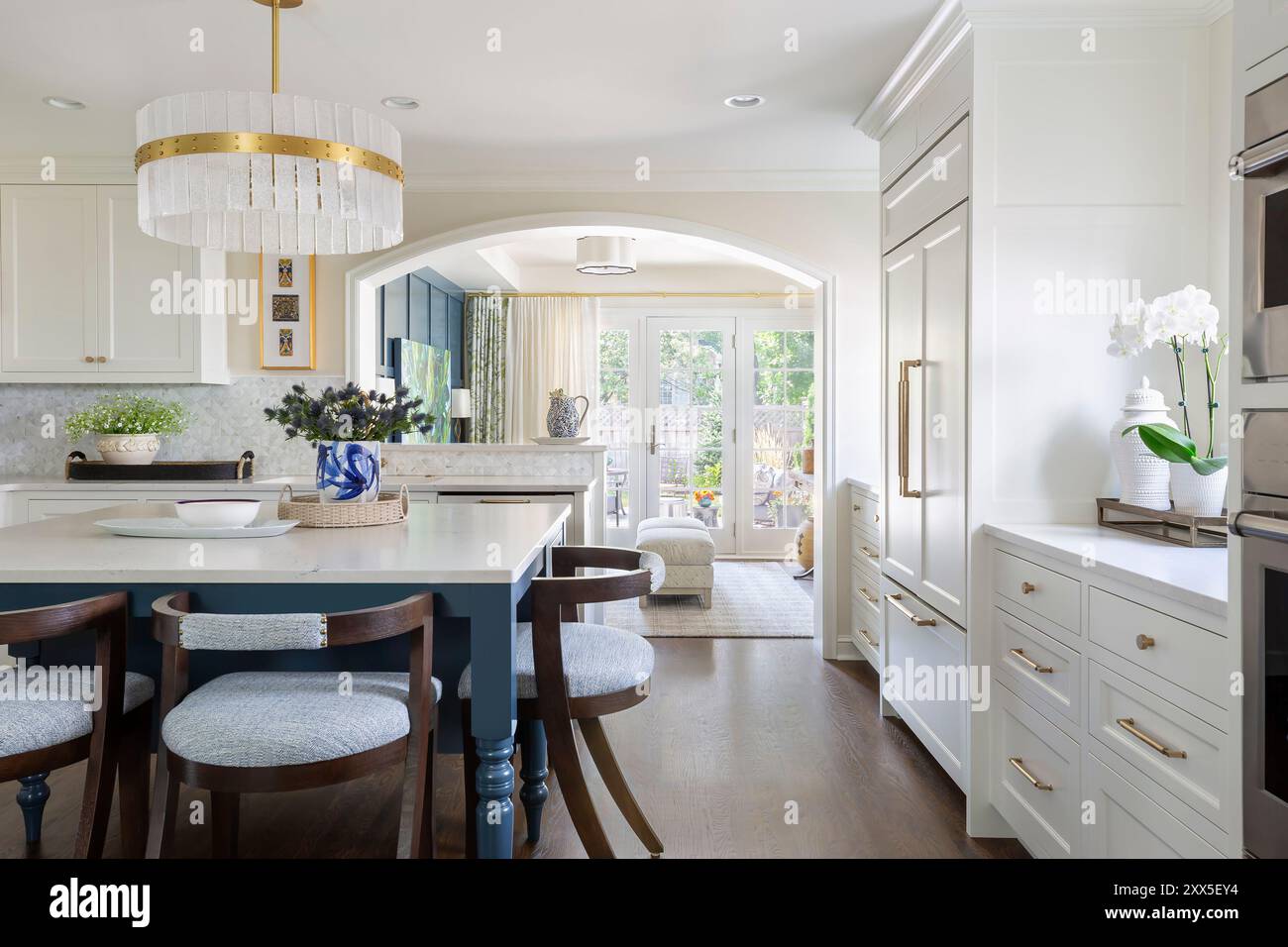 View into TV room from kitchen with arched entryway Stock Photo - Alamy