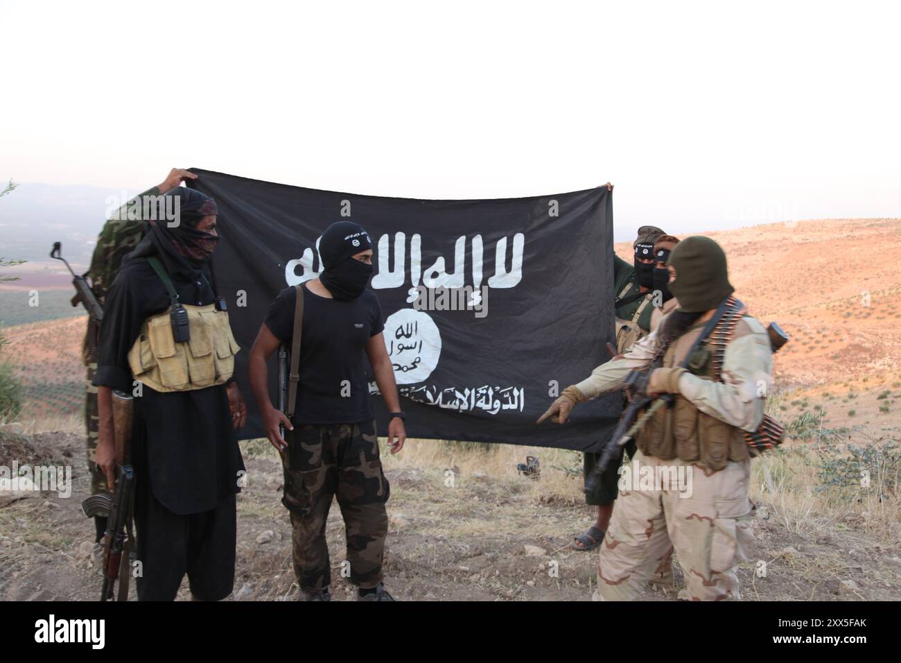 ISIS fighters holding the Al-Qaeda flag with 'Islamic State of Iraq and ...