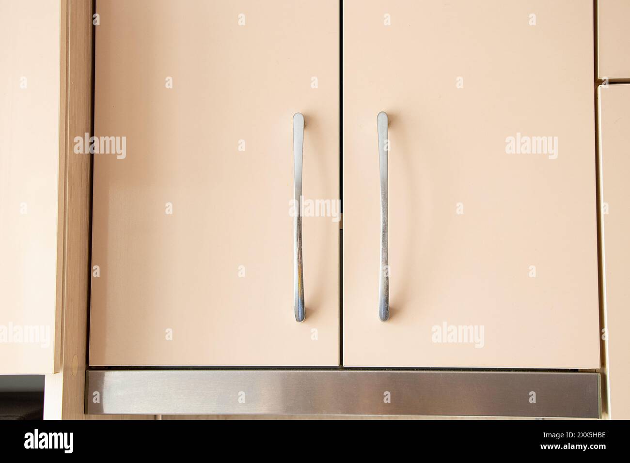 Beige kitchen cabinet with handles as background, close-up of kitchen ...