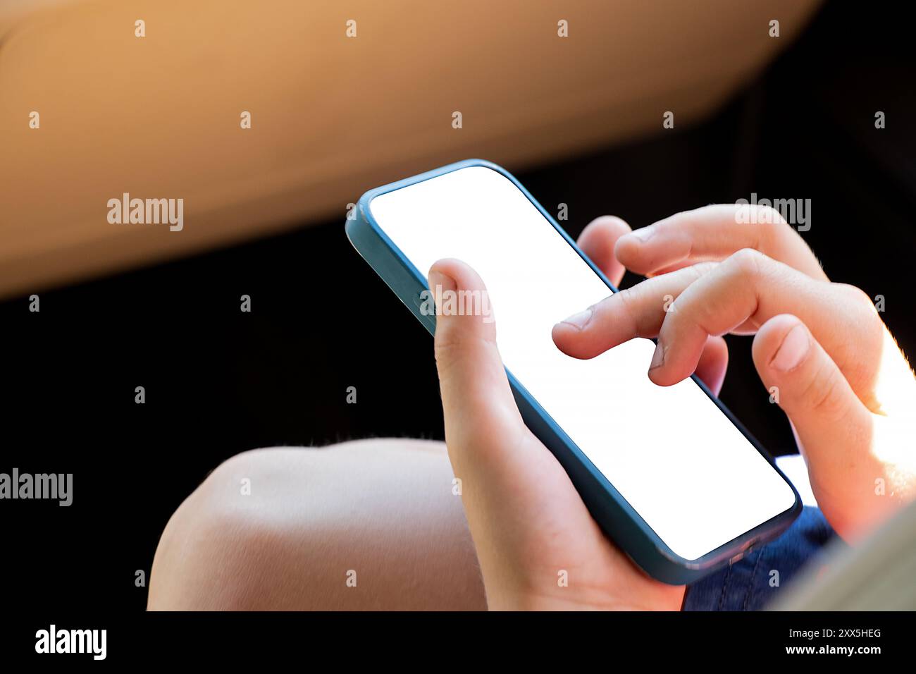 Little boy's hands holding a phone with a white screen during the day ...
